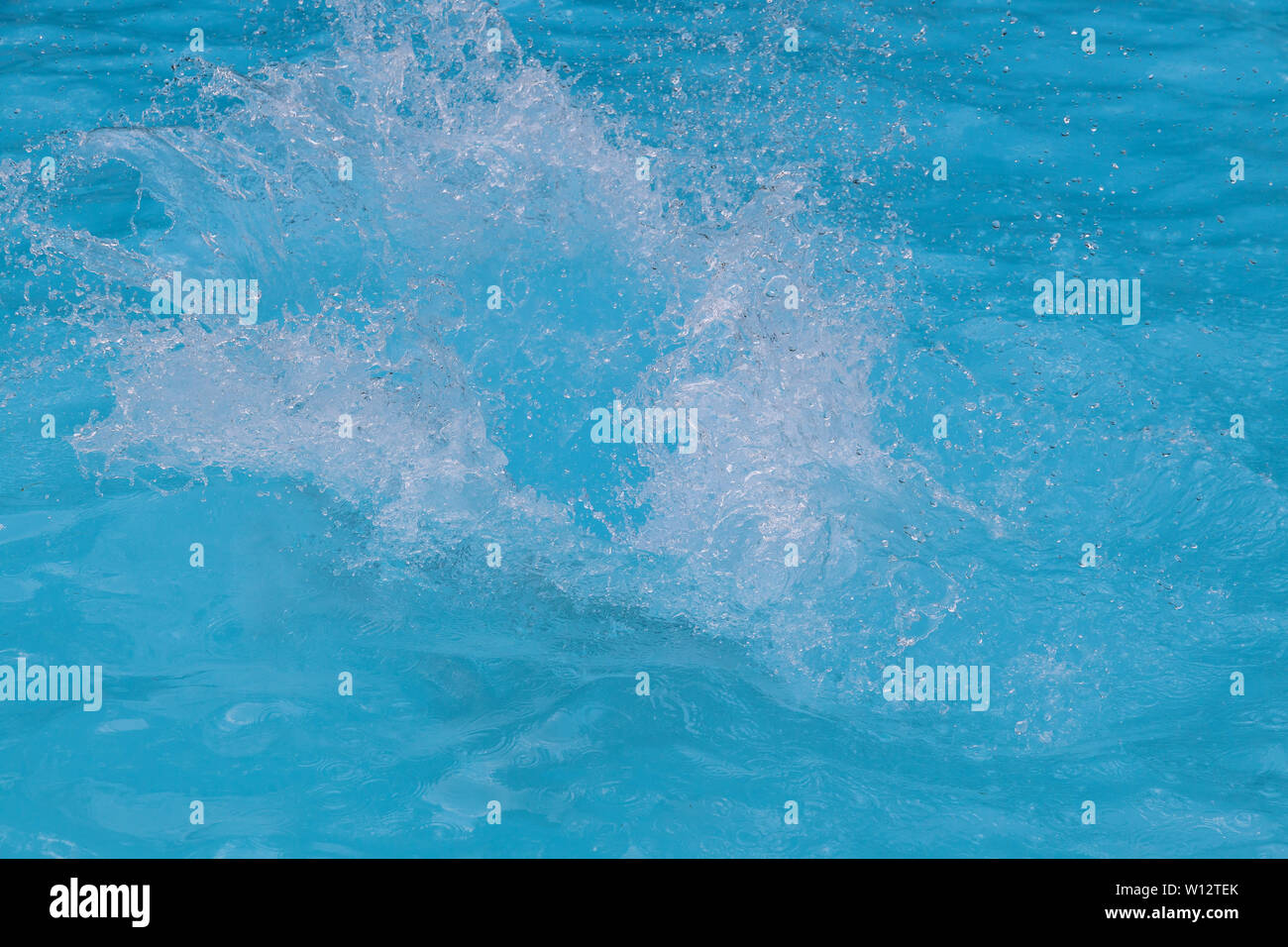 Droplets of blue water over circles on the pool water drop and splash ...
