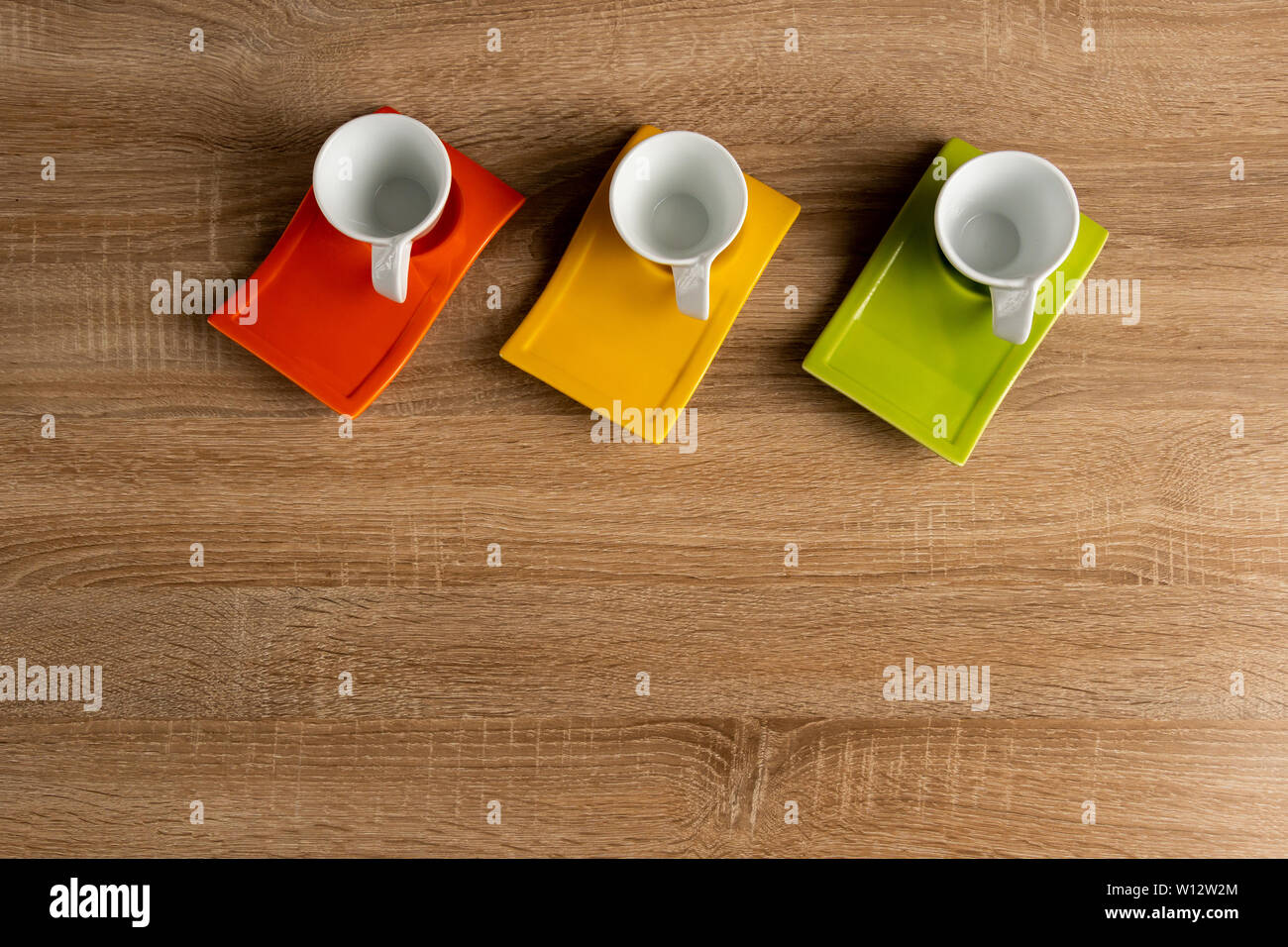 Three empty cups of coffee placed on desk up center, tilted left. Table ...