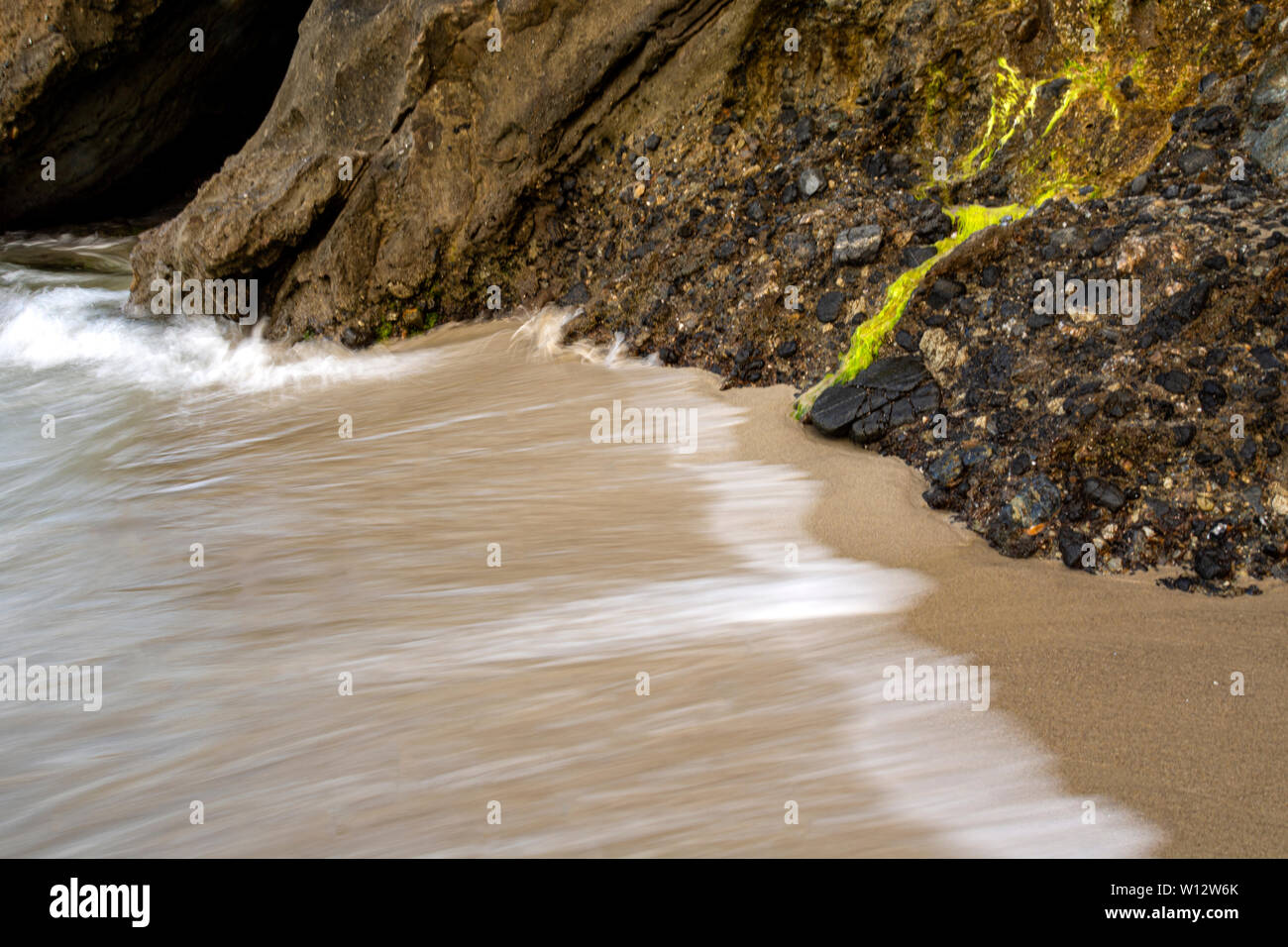 Crashing waves against rocks, moss and a cave in Laguna Beach ...
