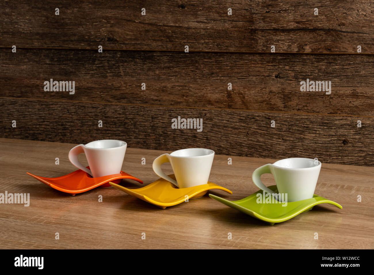 Side left to right inclined view of white coffee cups place on three ...