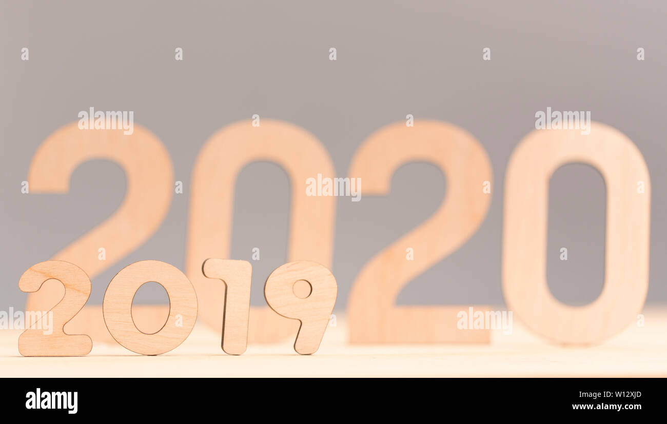 Big wooden 2020 numbers displacing 2019 on grey background Stock Photo ...