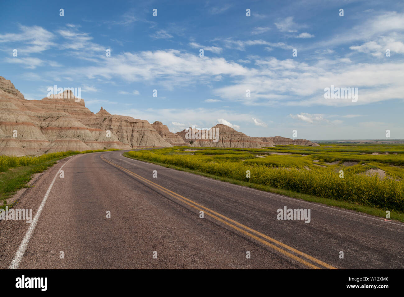 A road leads into the dramatic landscape of Badlands National Park with ...