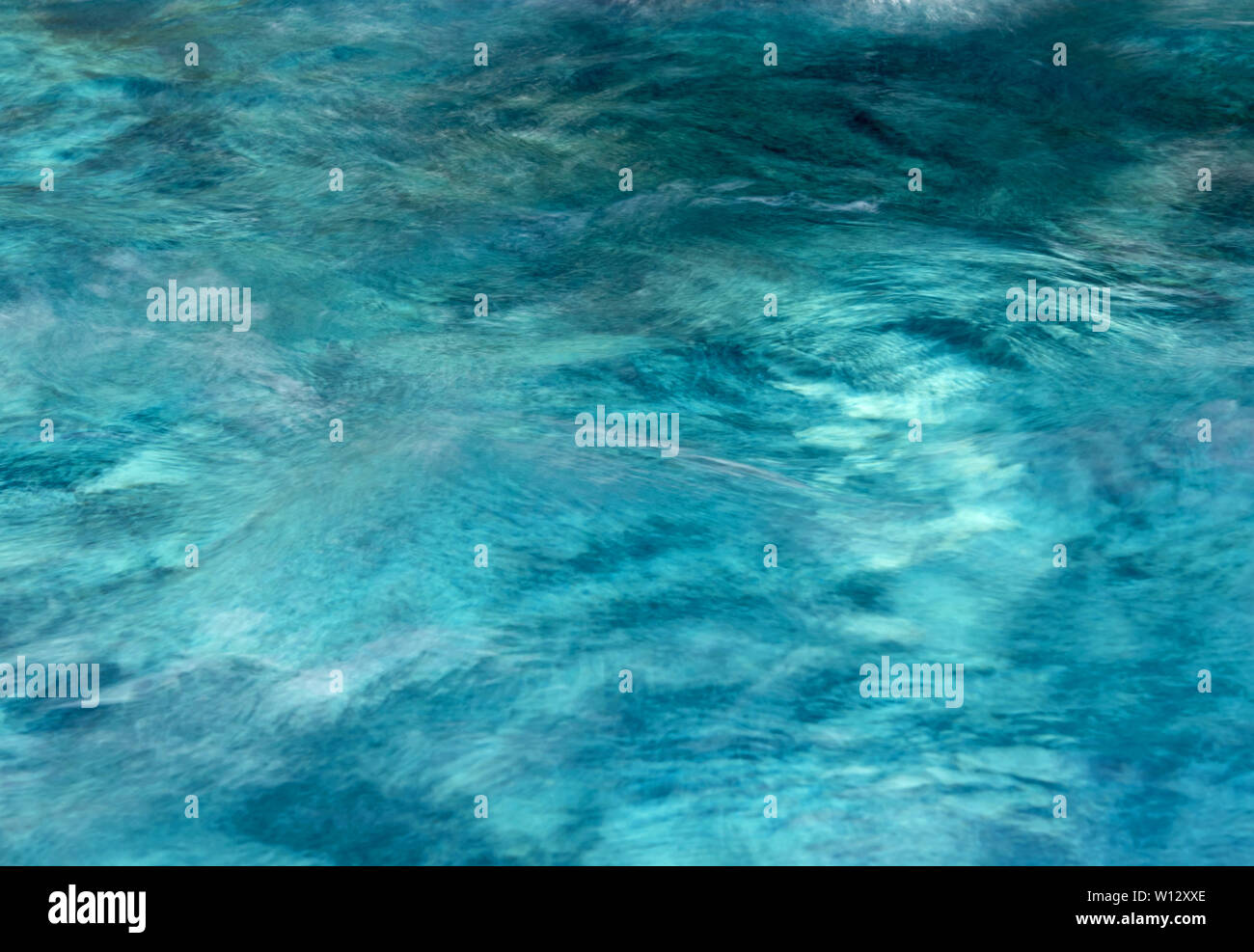 Reflection of sunlight and blue sky on the moving water surface in the ...