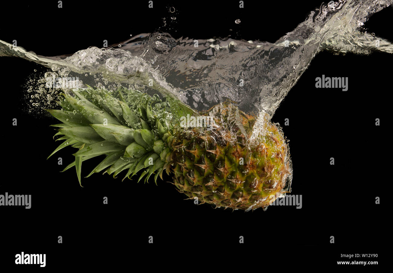 Pineapple falling under water with big splash Stock Photo - Alamy
