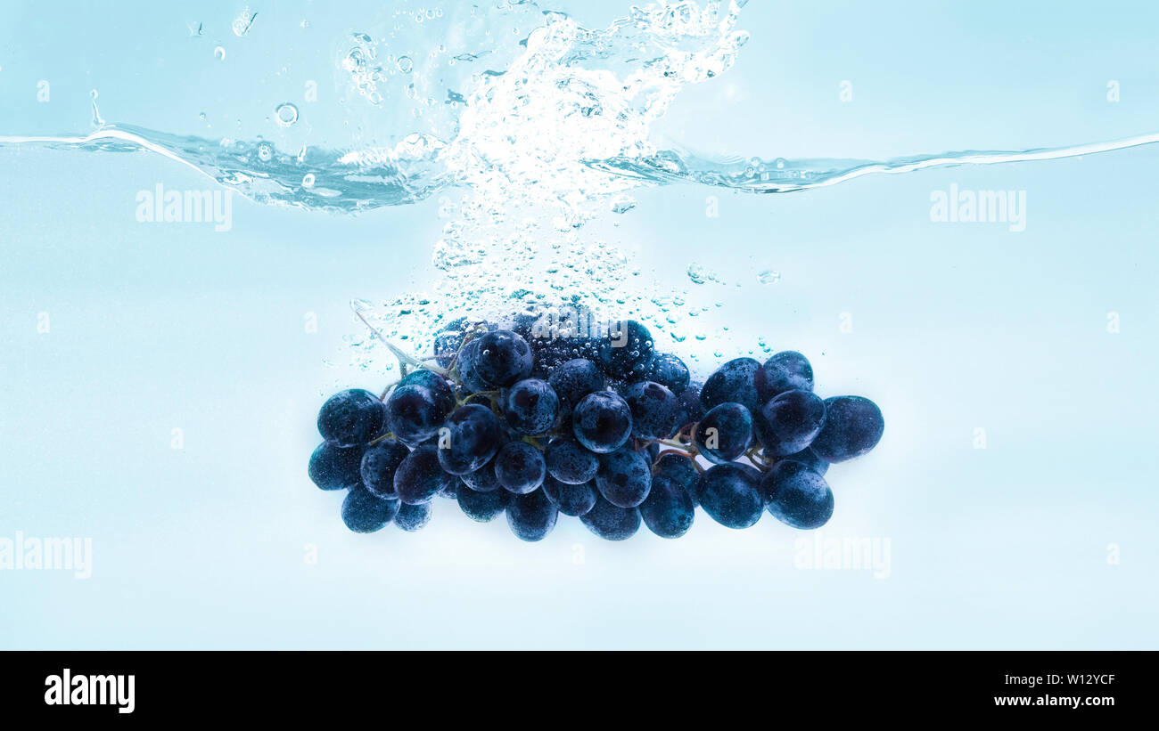 Ripe grapes falling deeply under water with big splash Stock Photo - Alamy