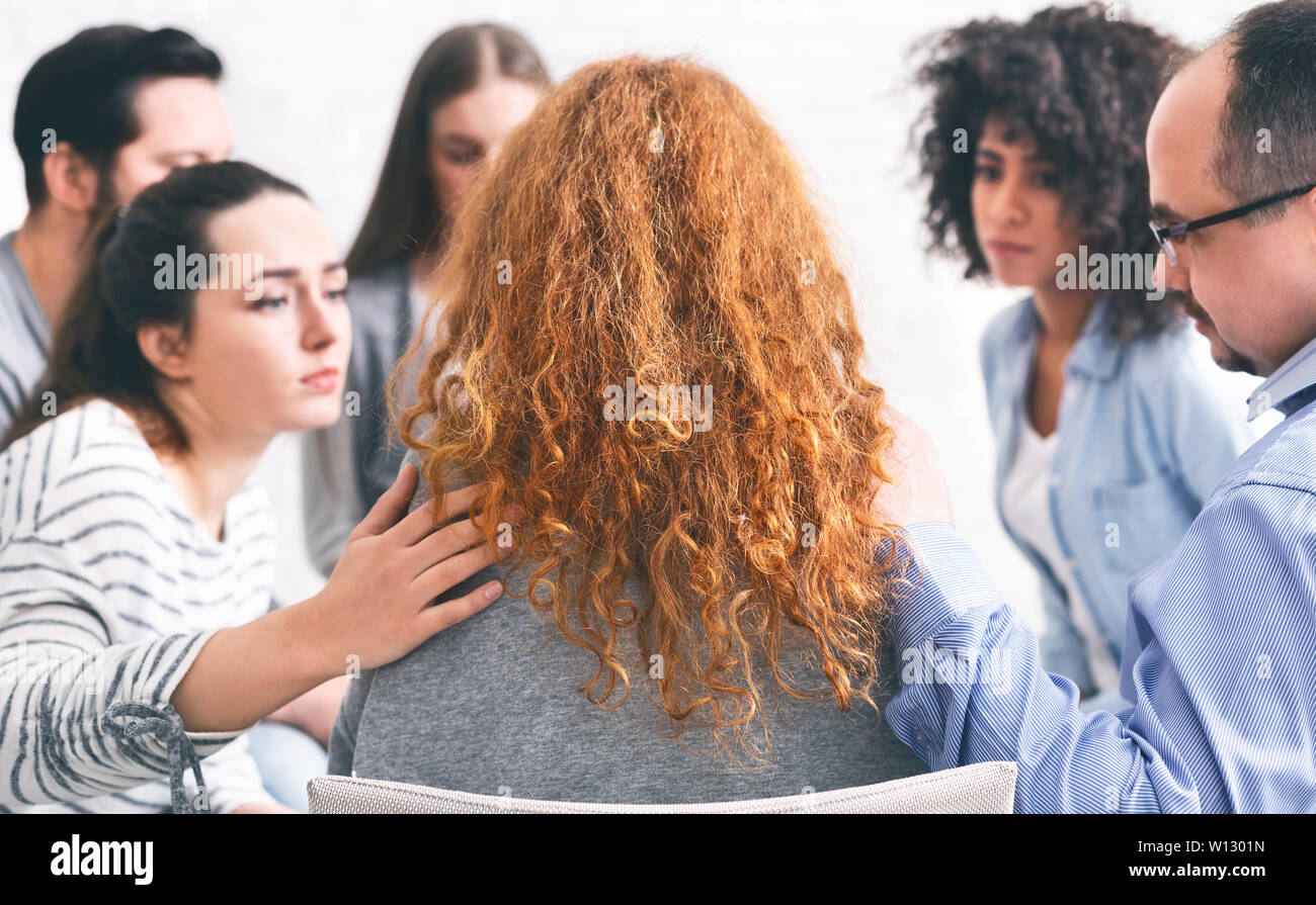 Caring people comforting depressed woman at support meeting Stock Photo ...