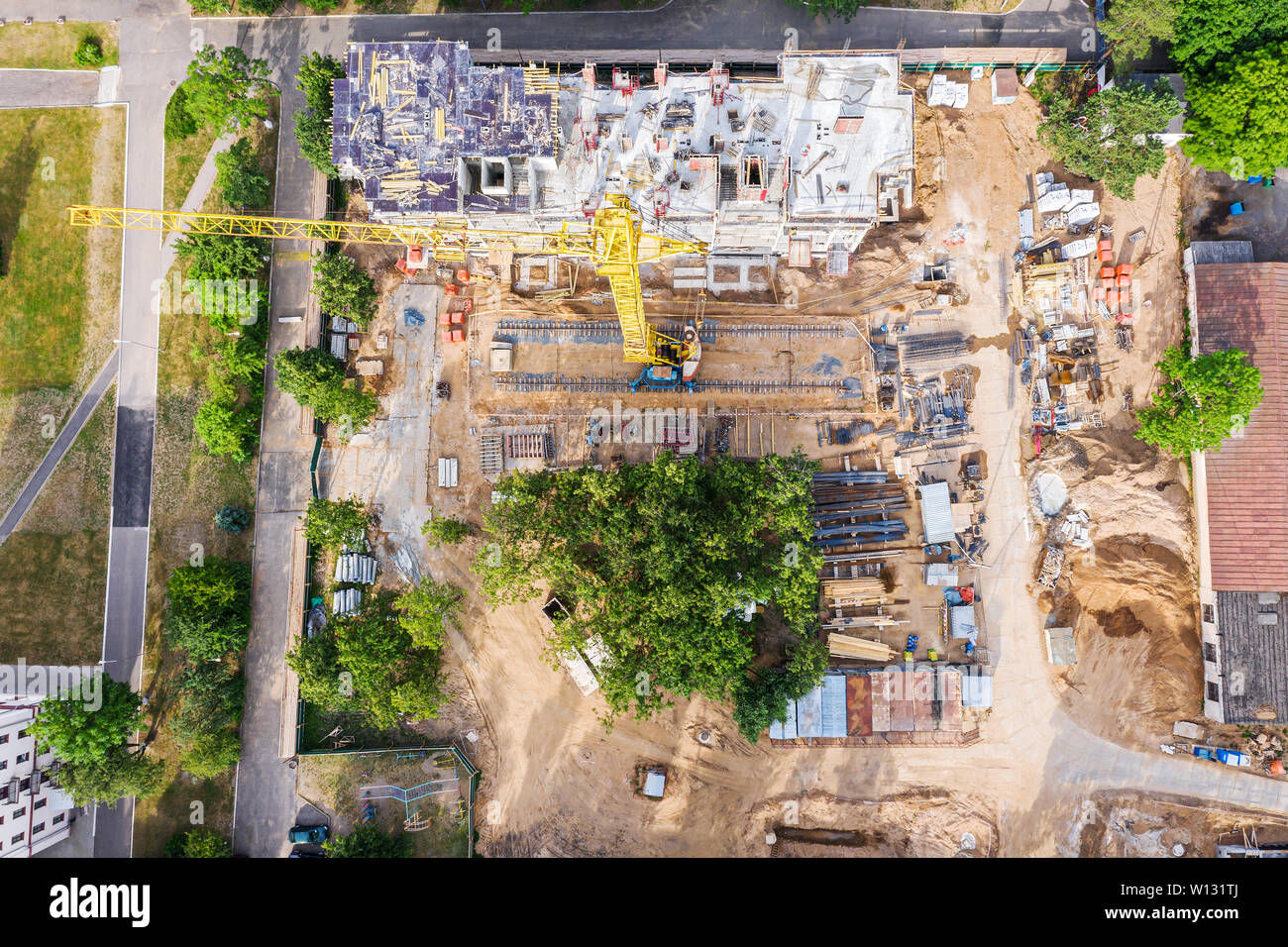 aerial top view of city construction site with yellow crane. apartment ...