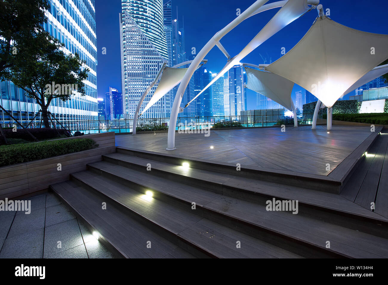 Illuminated empty footpath near modern building Stock Photo - Alamy