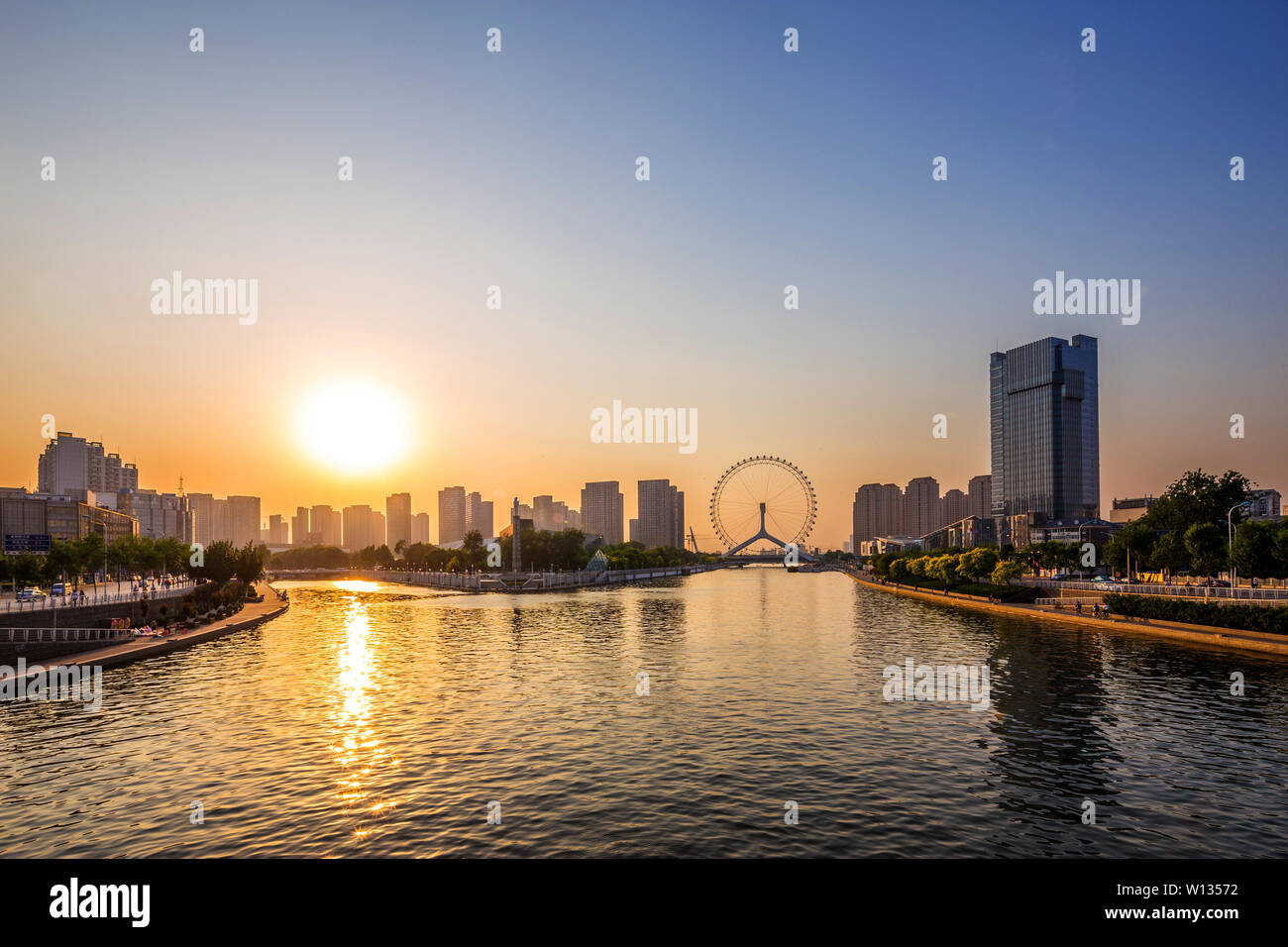 modern city skyline and buildings at riverbank during sunset Stock ...