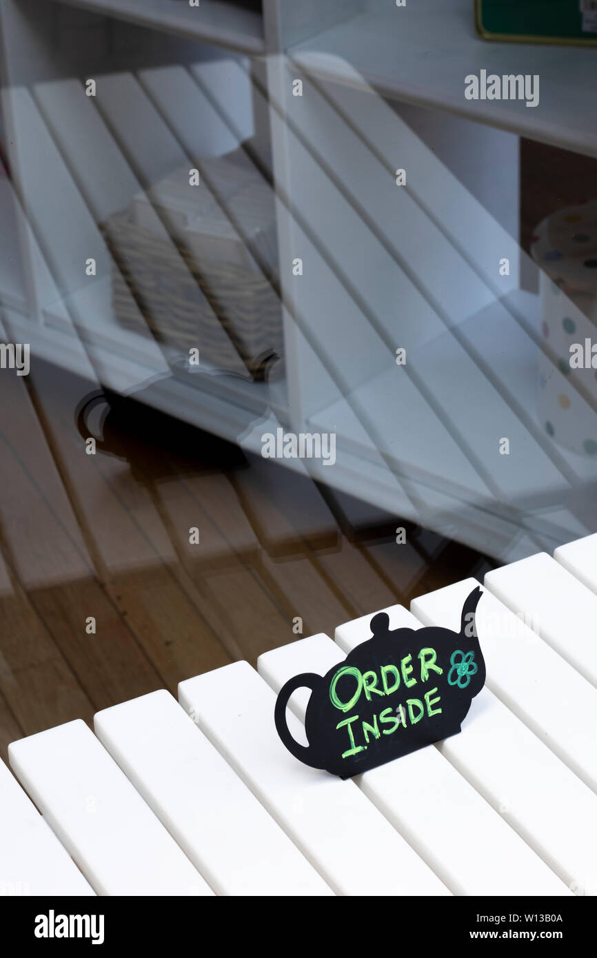 Cafe information order inside teapot sign on wooden white table outside ...