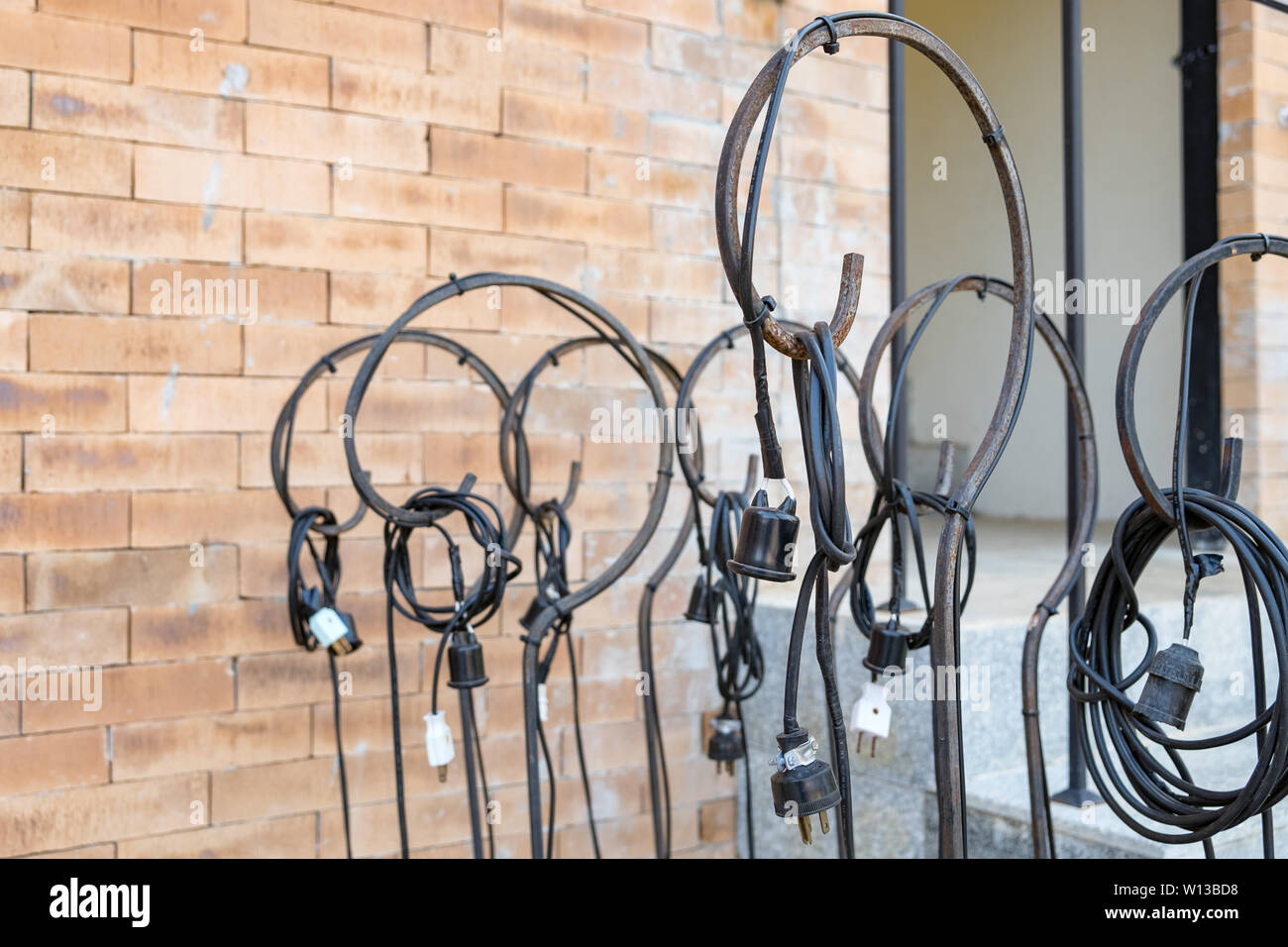 Black wire and plug hanging on steel pole side brick wall Stock Photo ...