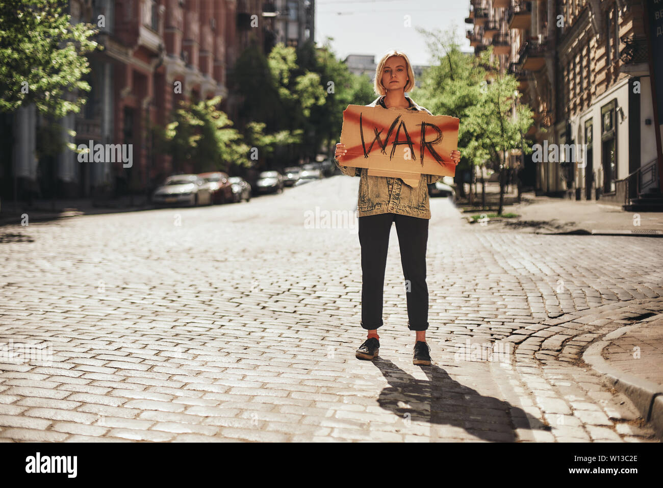 I hate war Full length of young confident female holding a signboard ...