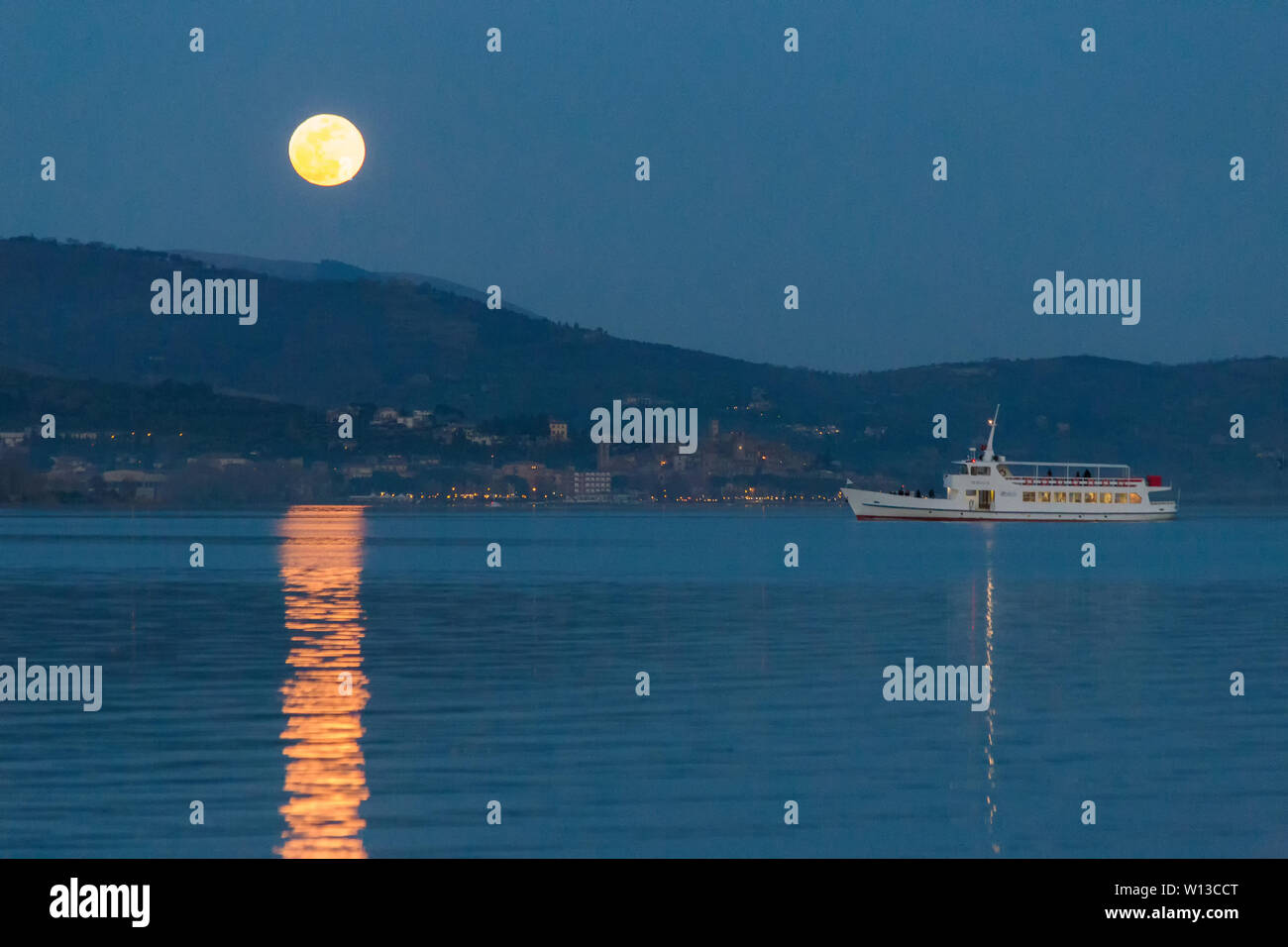 Full moon rising over some hills on Trasimeno lake, perfectly ...