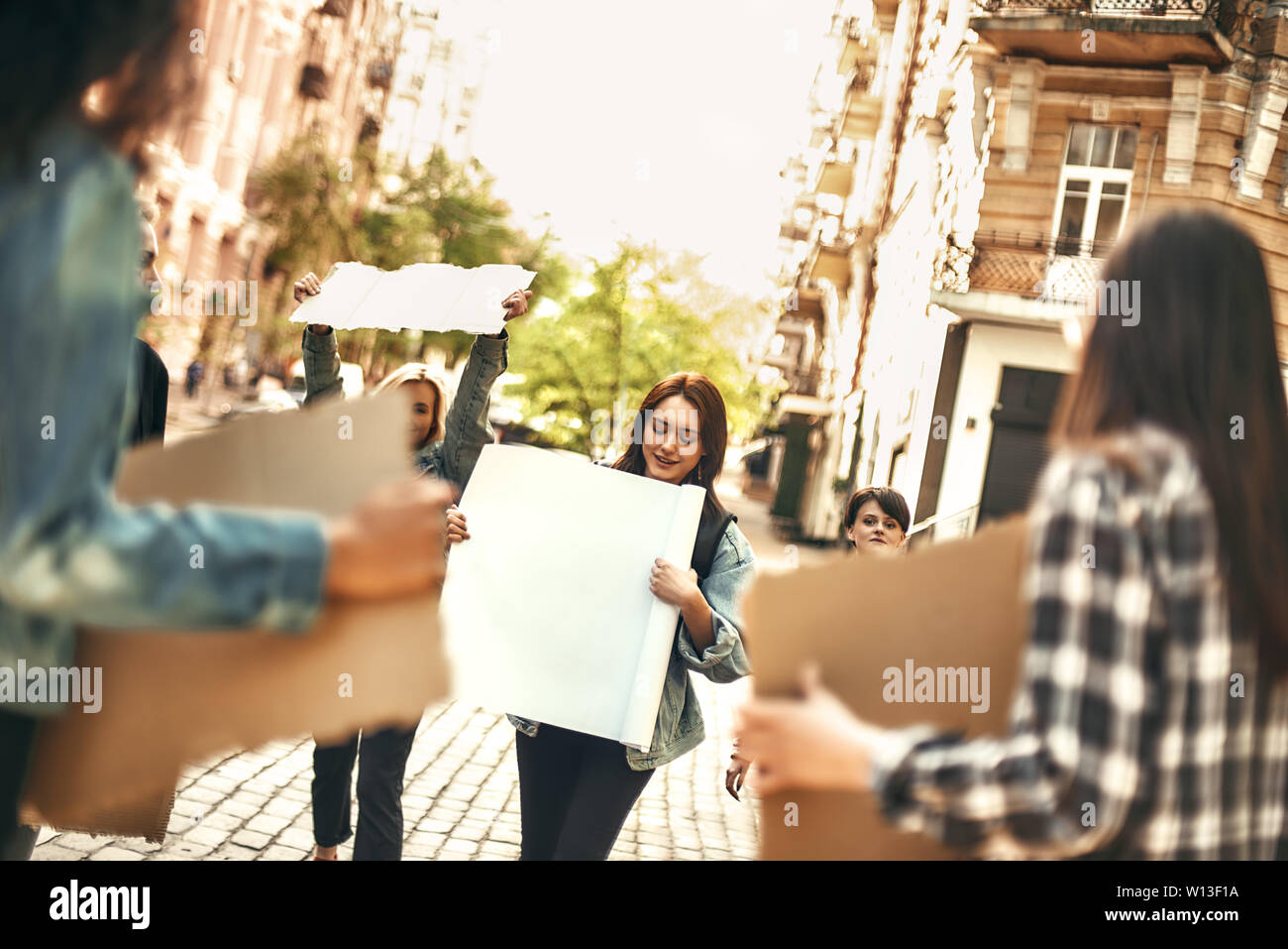 Protesting outdoors. Group of positive female activists holding sign ...