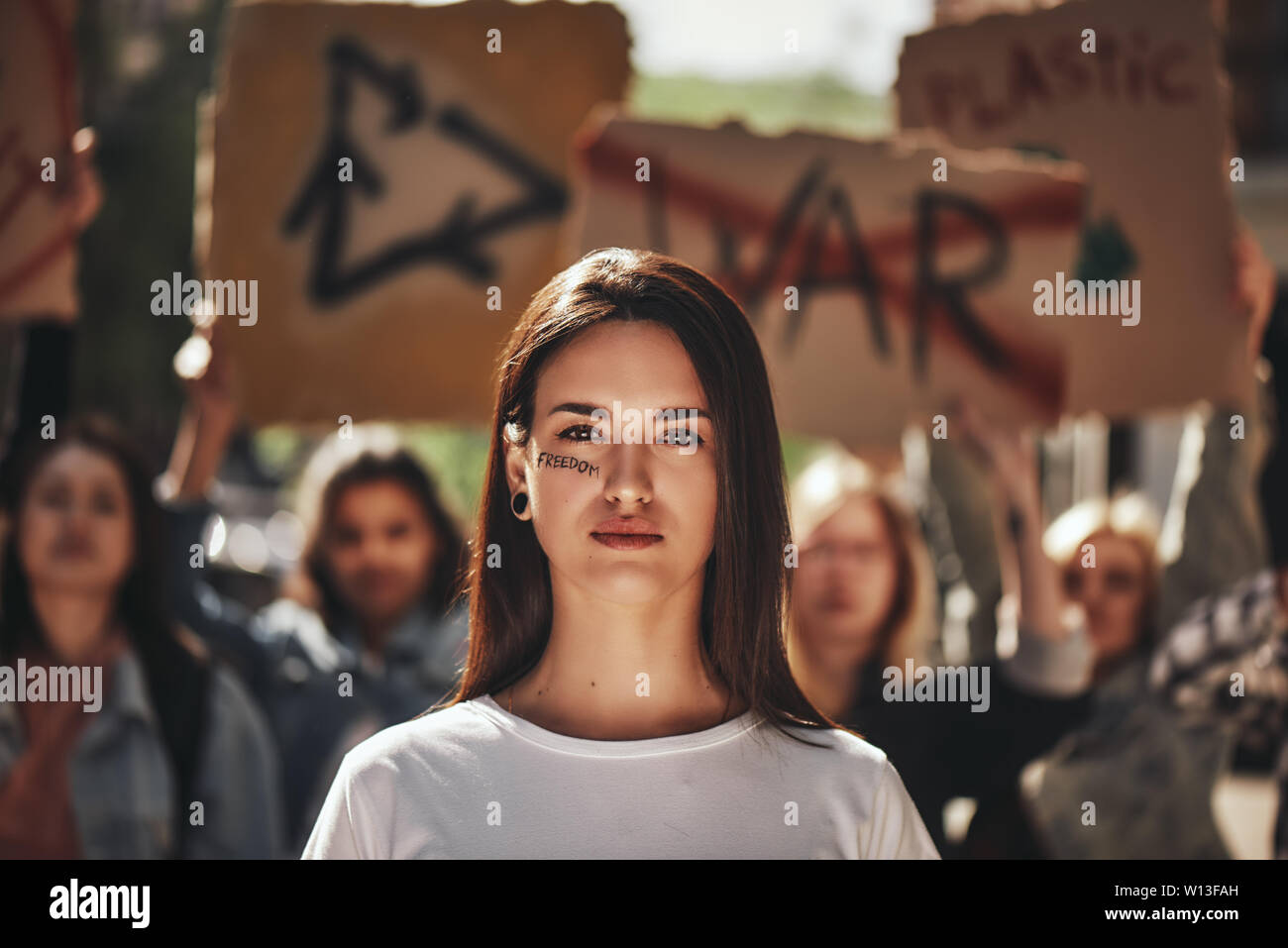 Female young activist with word freedom written on her face protesting ...