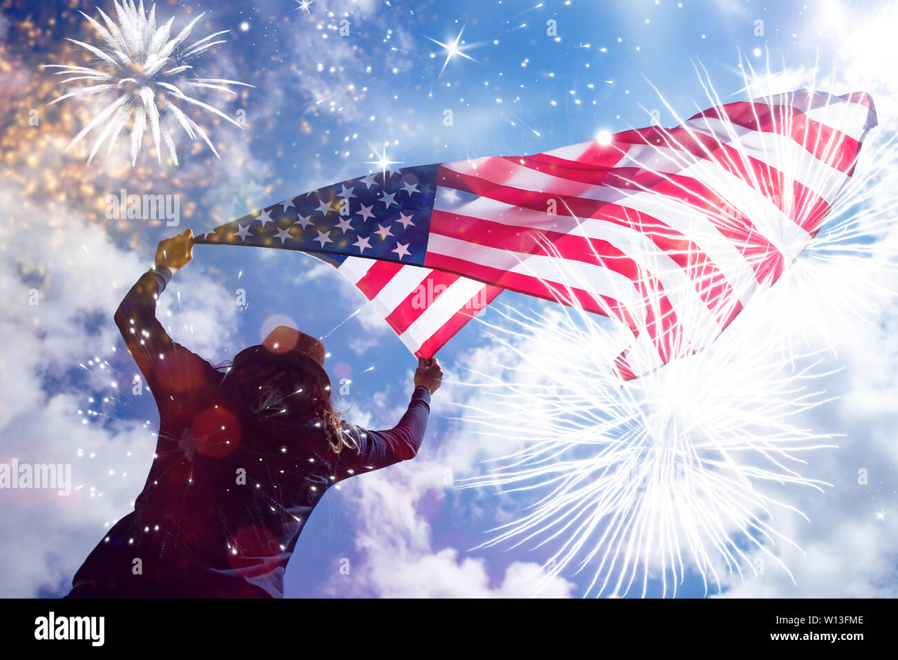 Young happy patriot girl holding the american flag under the 4th of ...