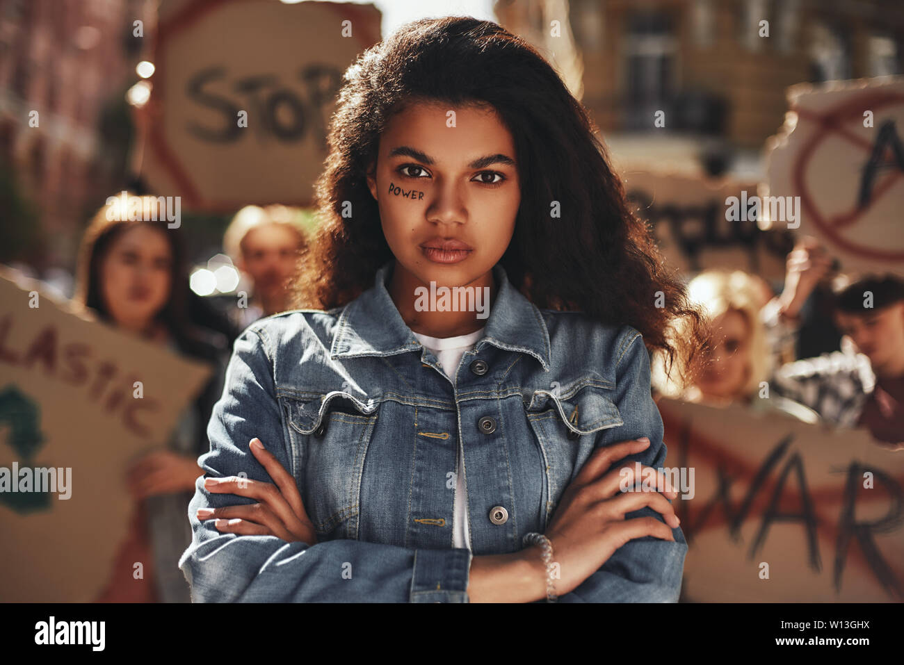 Afro american woman with word power written on her face keeping arms ...