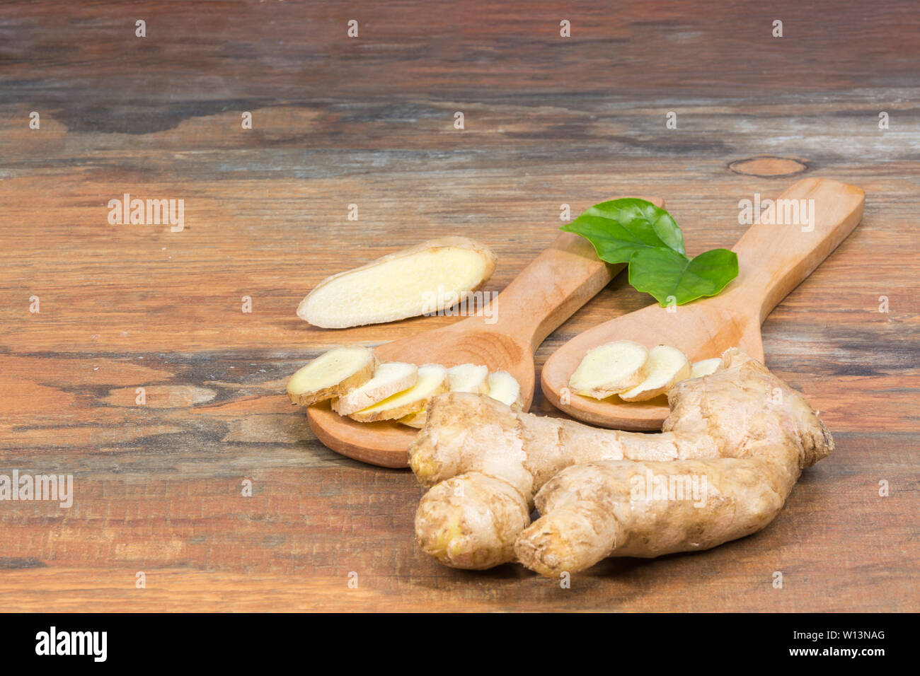 Ginger and cut ginger slices on table Stock Photo - Alamy