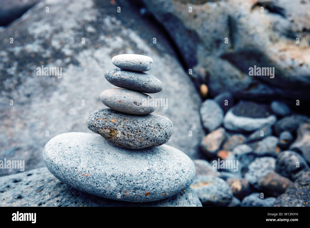 folded pyramid of smooth stones on the seashore, zen stone, symbol of ...