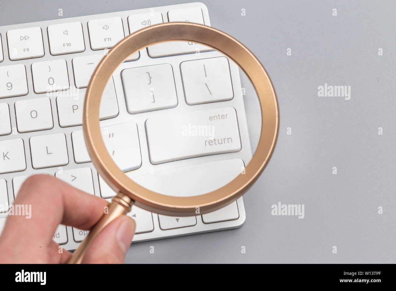 A magnifying glass and a keyboard Stock Photo - Alamy