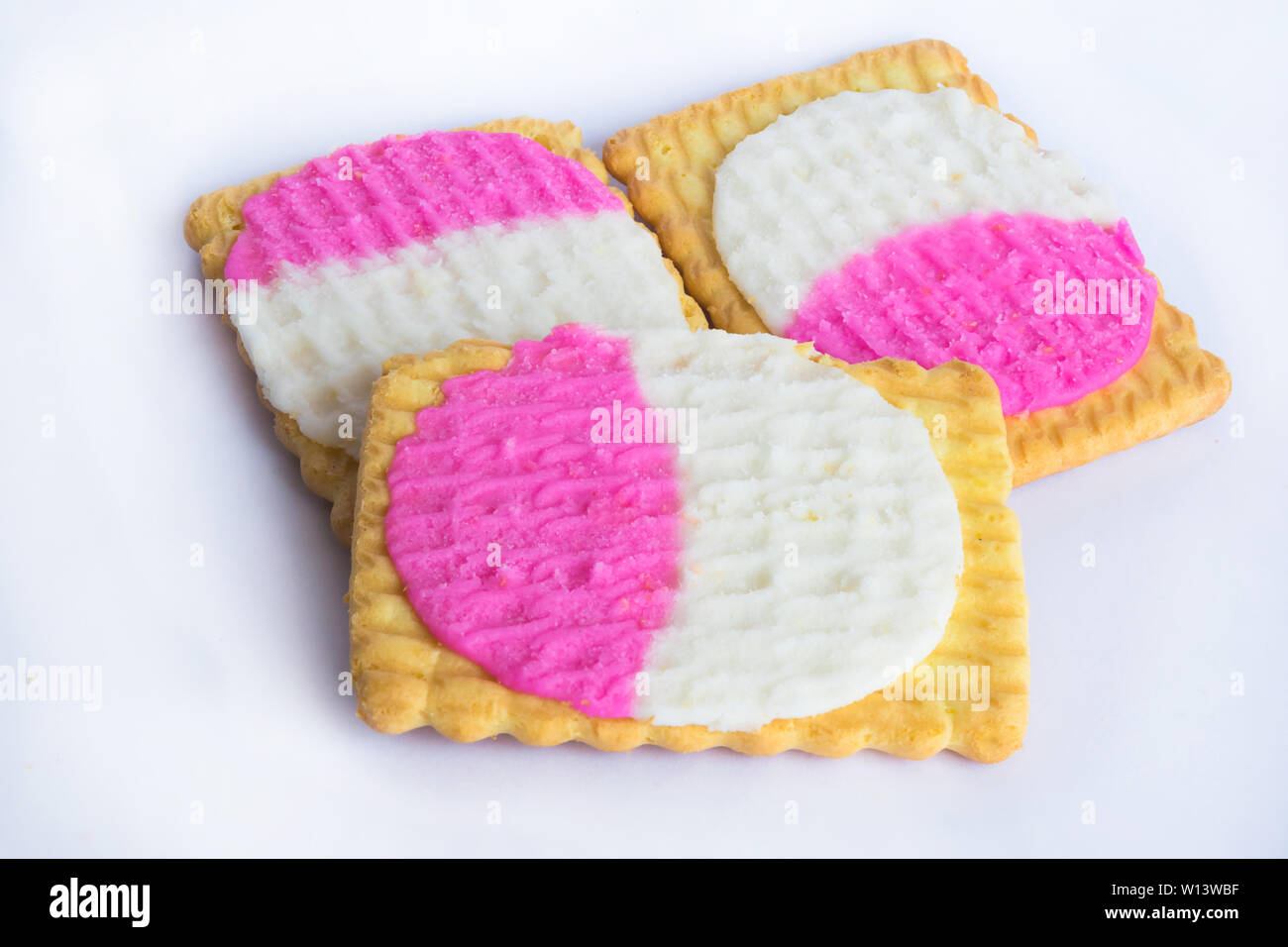 close up of square shape cream biscuits filled with white and pink ...