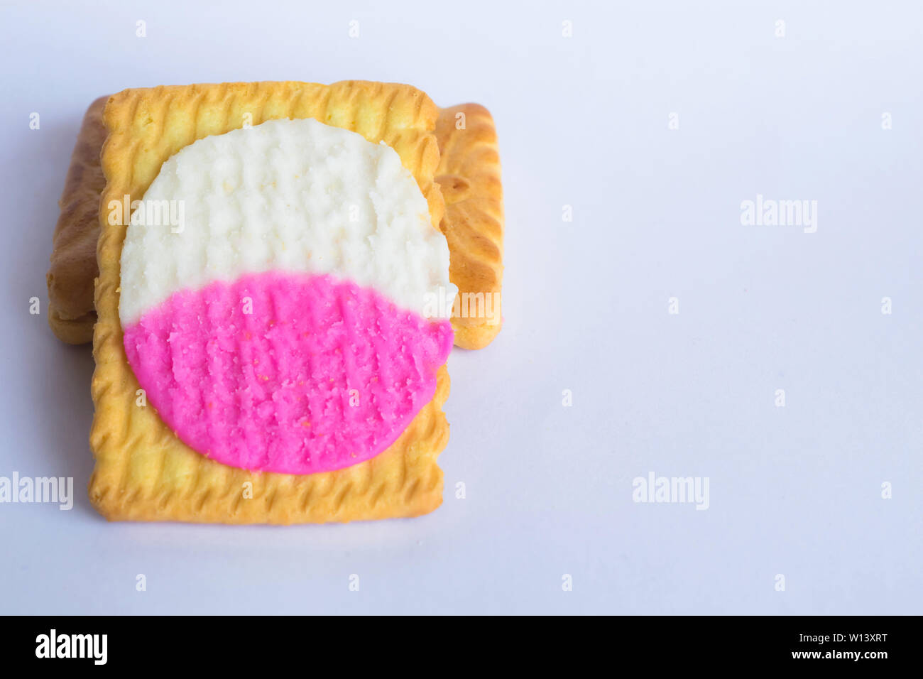 close up of square shape cream biscuits filled with white and pink ...