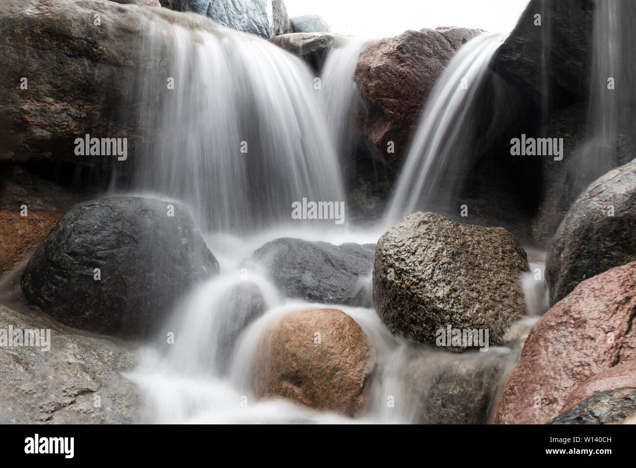 A series of waterfalls in Copenhagen, Denmark flow over smooth rocks ...