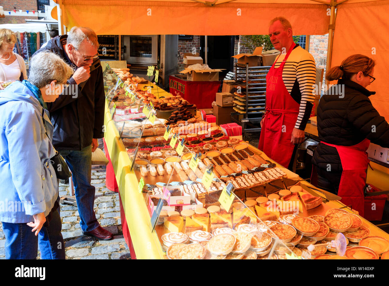 View along French bakery market stall in English cobbled town square ...