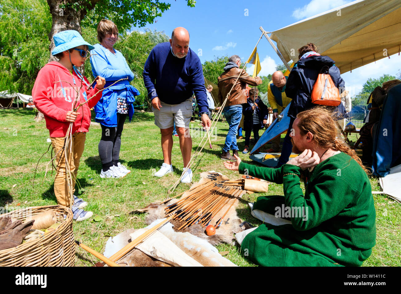 Members of the public standing looking at a long bow and collection of ...