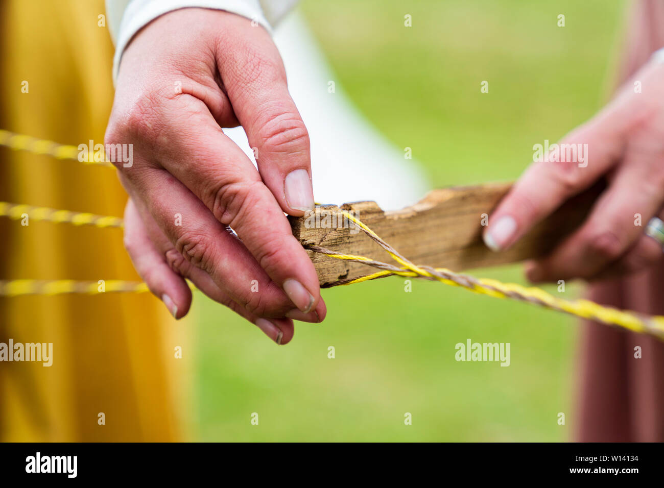 Living history medieval re-enactment. Close up of hands using wooden ...