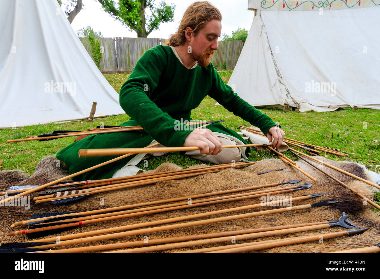 Medieval living history re-enactment. Man in period costume, sitting on ...
