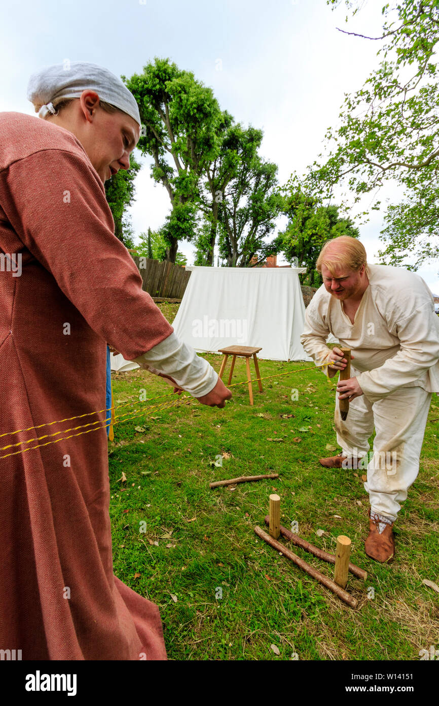 Living history medieval re-enactment. Rope maker, man twisting length ...