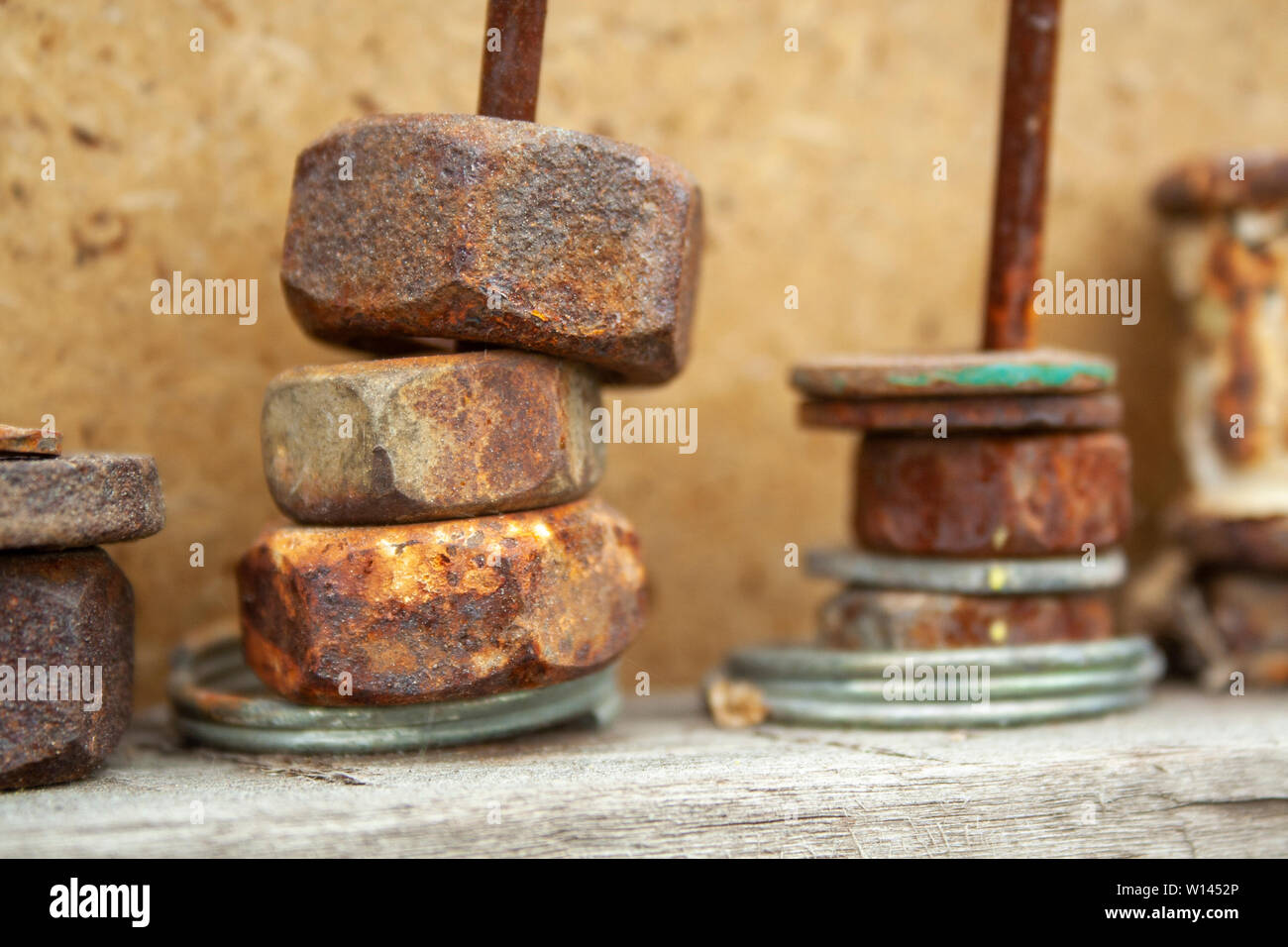 Organized old rusty nuts on grunge and aged nails on wooden background ...