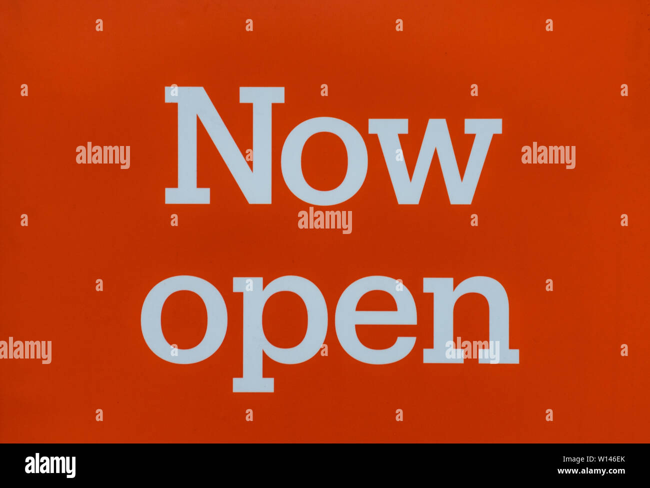 Now Open in White on Orange text Stock Photo - Alamy