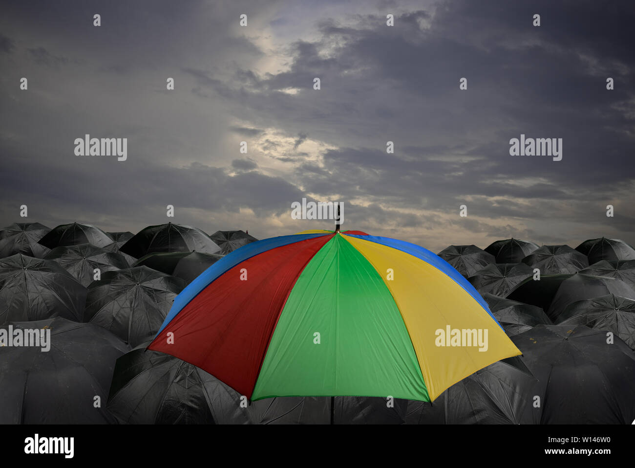 Colorful umbrella over many black umbrella in rainy season Stock Photo ...