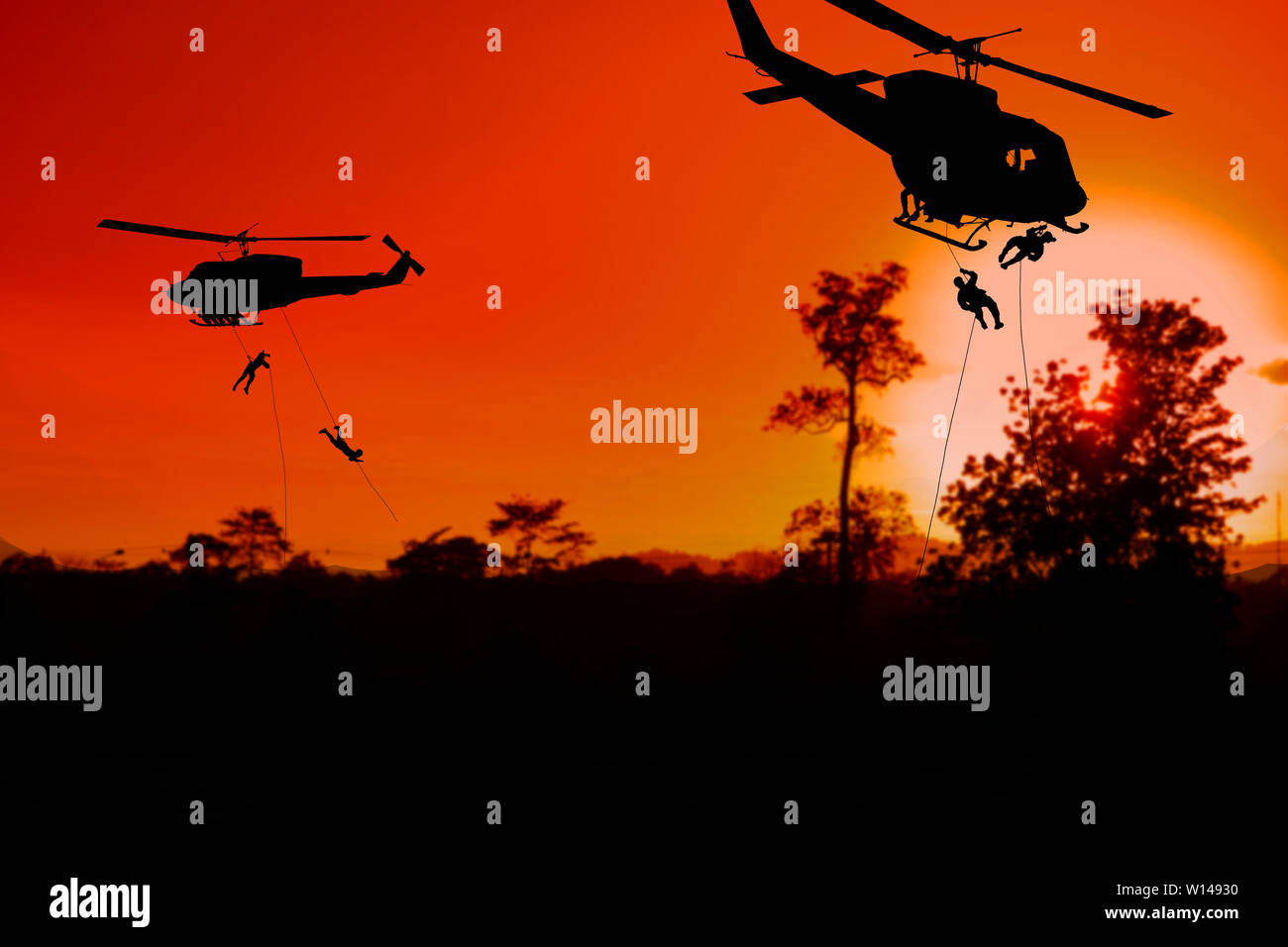 Silhouette Soldiers rappel down to attack from helicopter with sunset ...