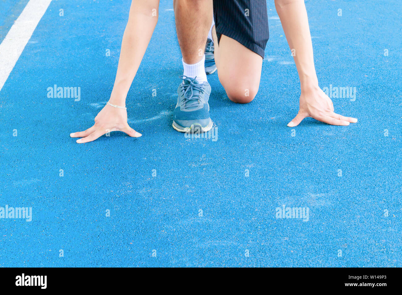 arm male touch floor start pose training running on track rubber blue ...