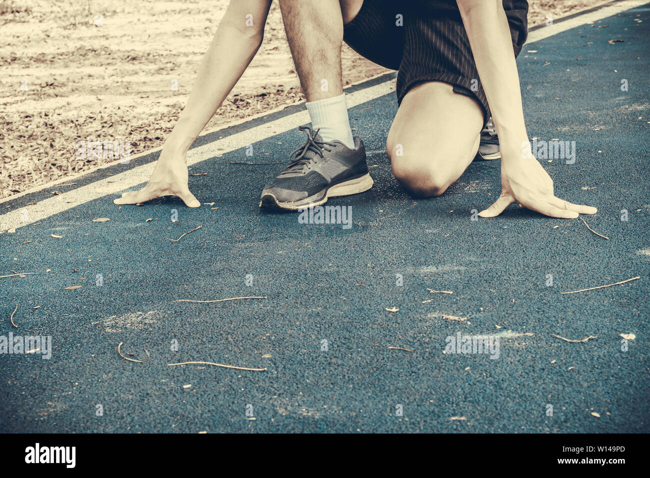 arm male touch floor start pose training running on track rubber blue ...