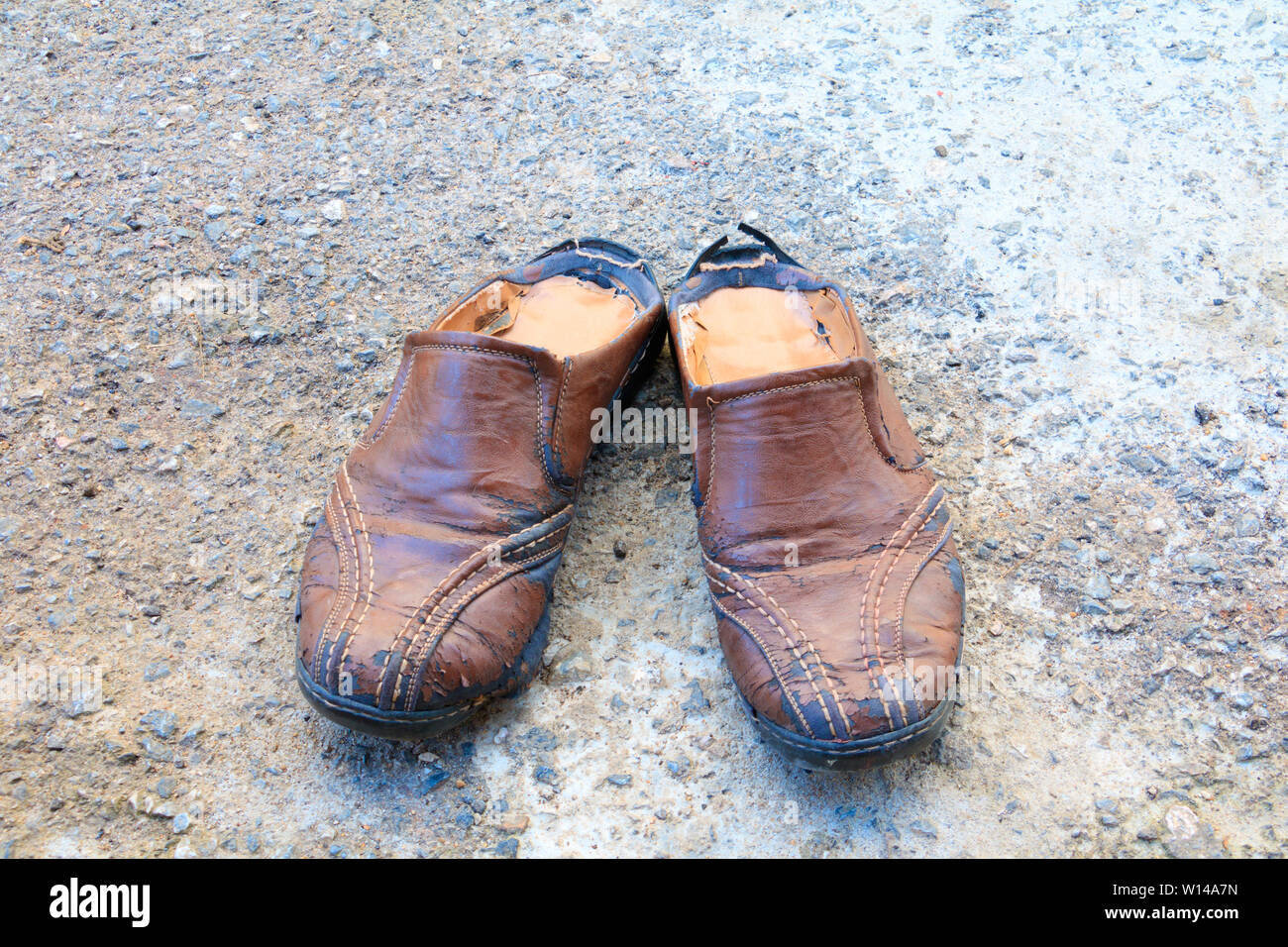 old shoes leather worn out On floor road background Stock Photo - Alamy