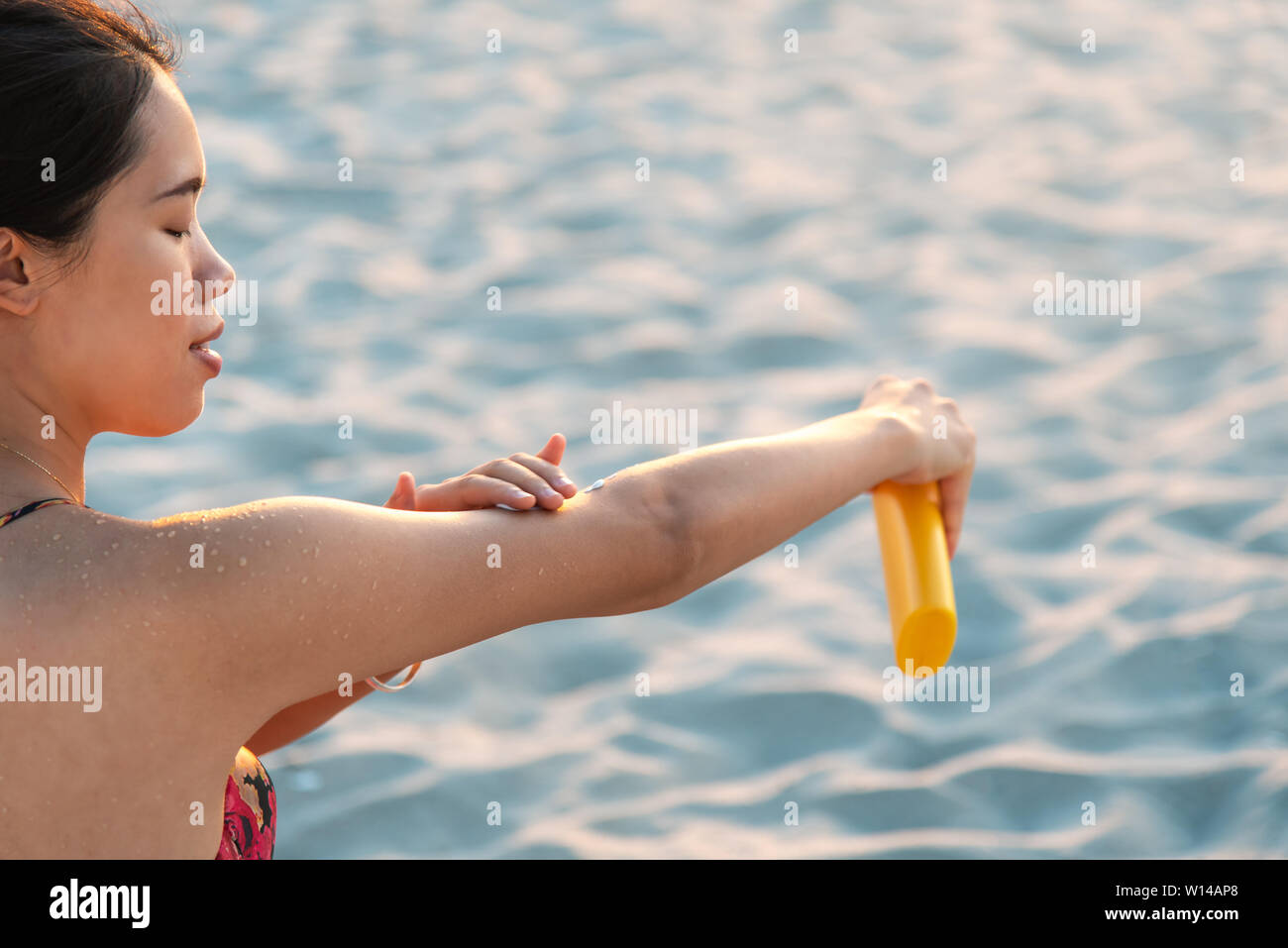 Woman using sun lotion on beach summer vacation Stock Photo - Alamy