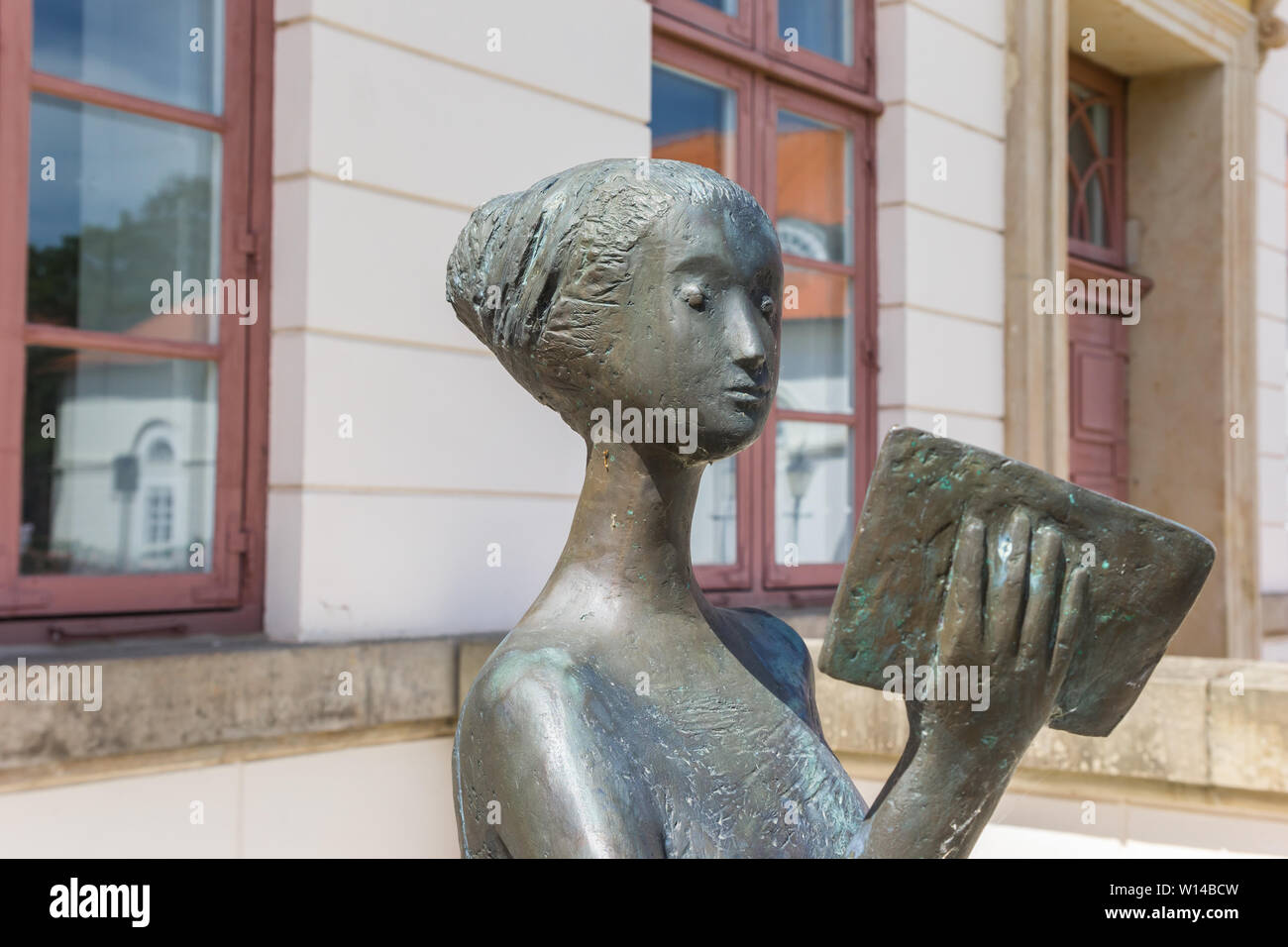 Sculpture of a woman reading in front of the library in Eutin, Germany ...
