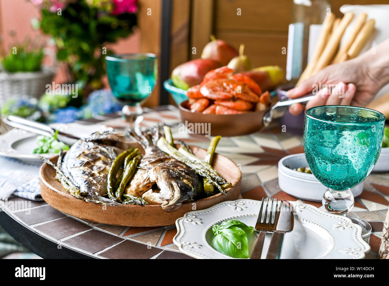Fried fish on a plate. Dining table with different food and snacks ...