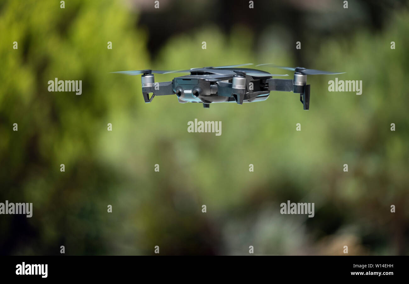 dark grey drone flying over a green background Stock Photo - Alamy