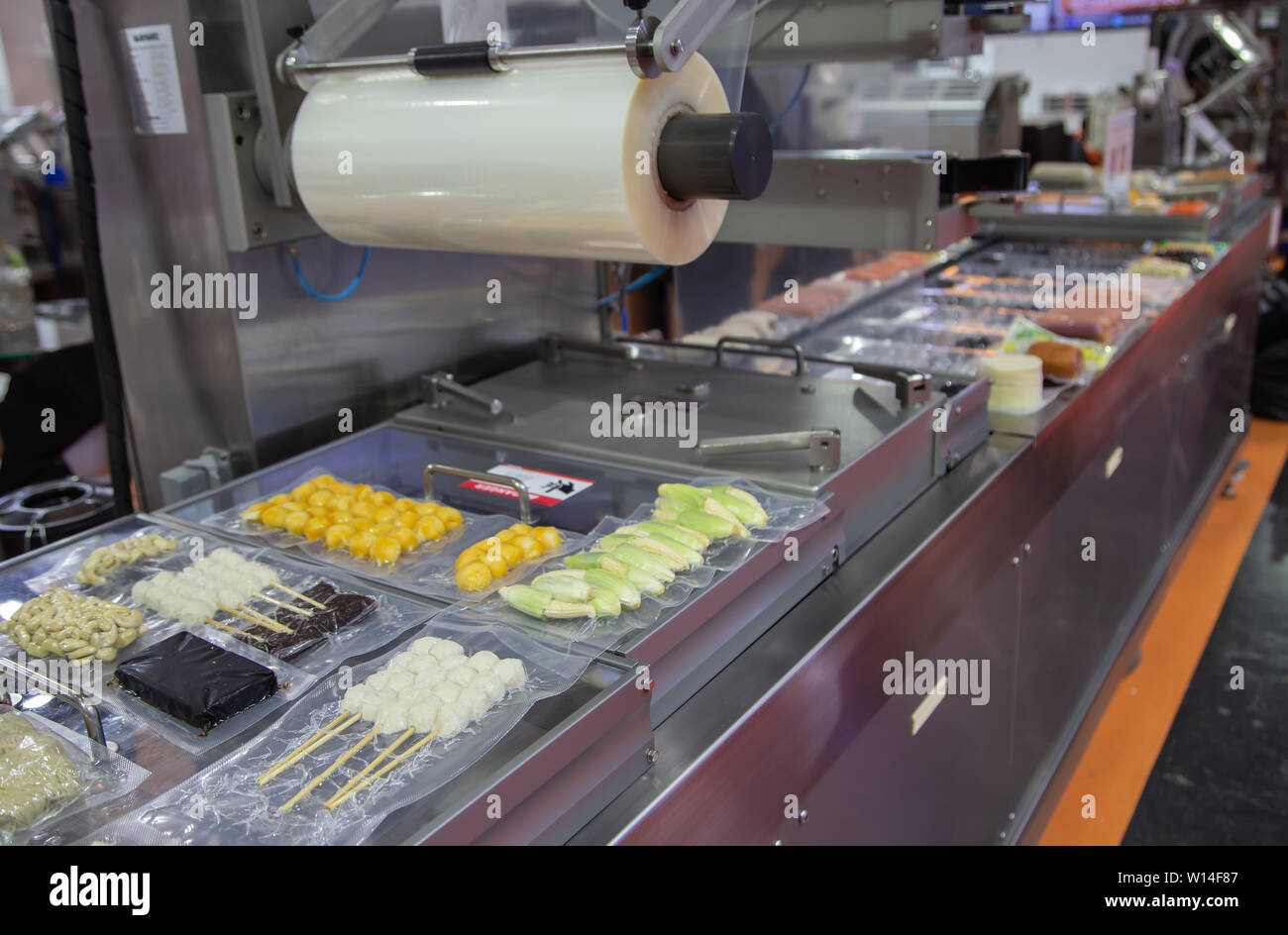 Linear tray food heat sealing and packaging machine Stock Photo - Alamy