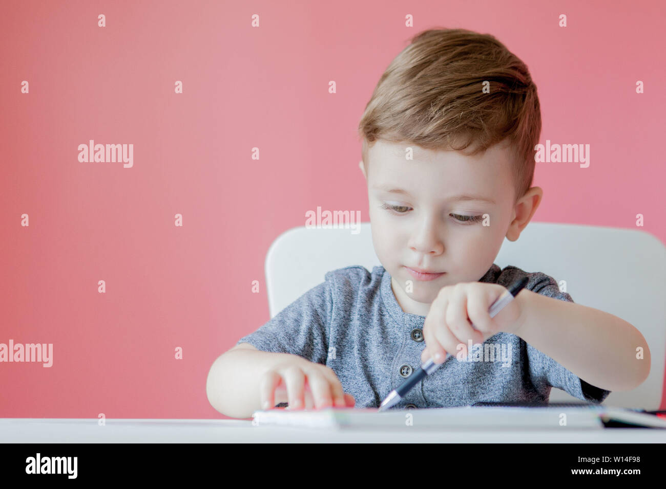 Portrait of cute kid boy at home making homework. Little concentrated ...