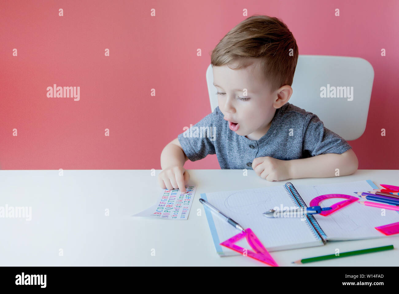 Portrait of cute kid boy at home making homework. Little concentrated ...