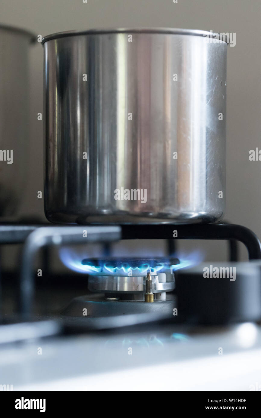 Close up of a blue gas flame, cooking a water pot in kitchen Stock ...