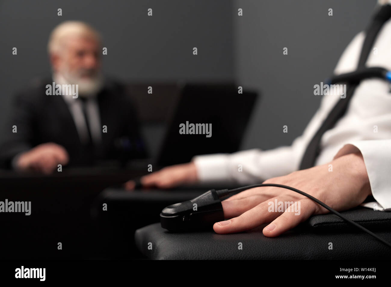 Closeup of pulse indicator on male hand during lie detector test. Adult ...