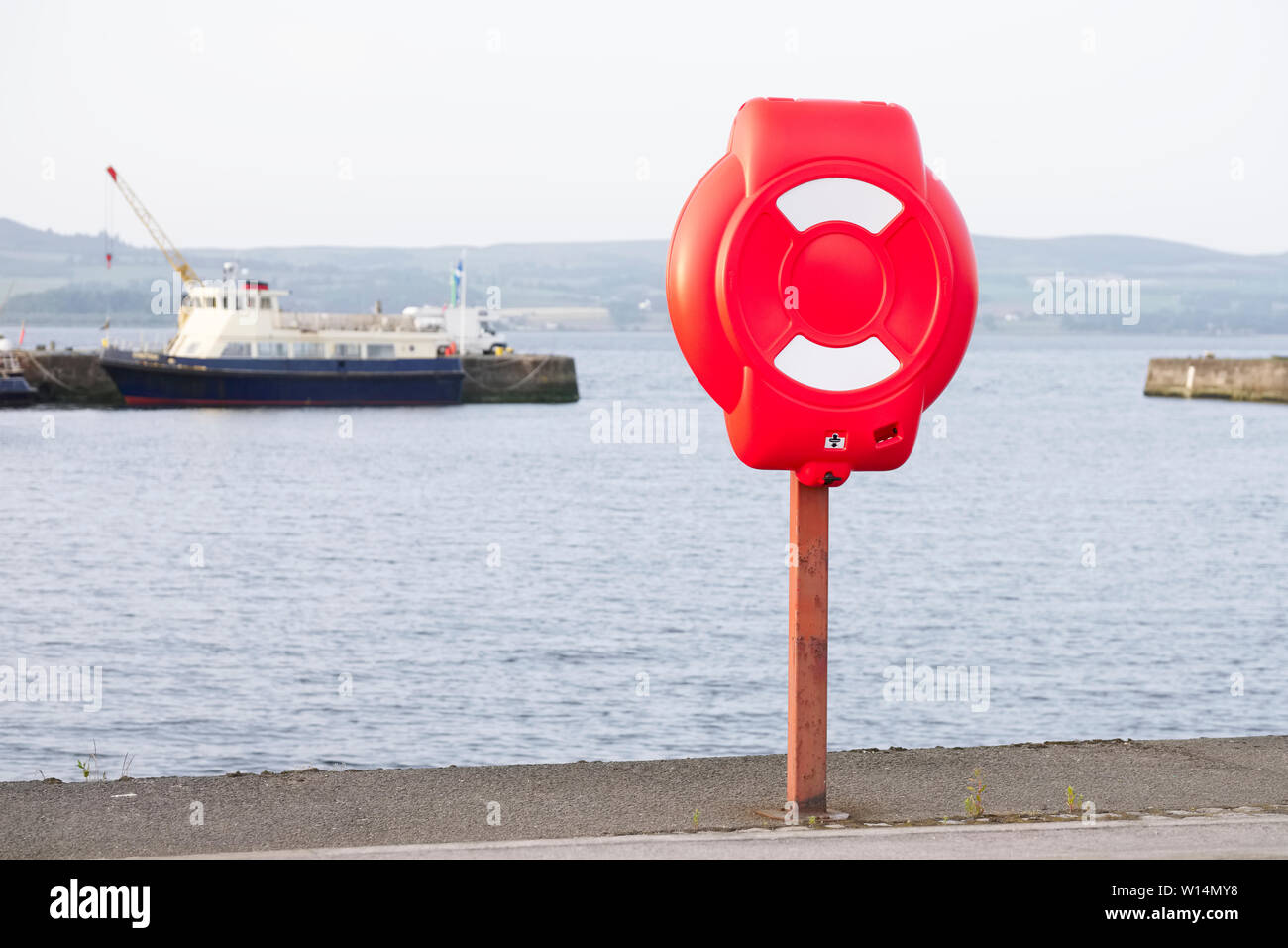 Red ring for water safety at sea dock and ships in background Stock ...