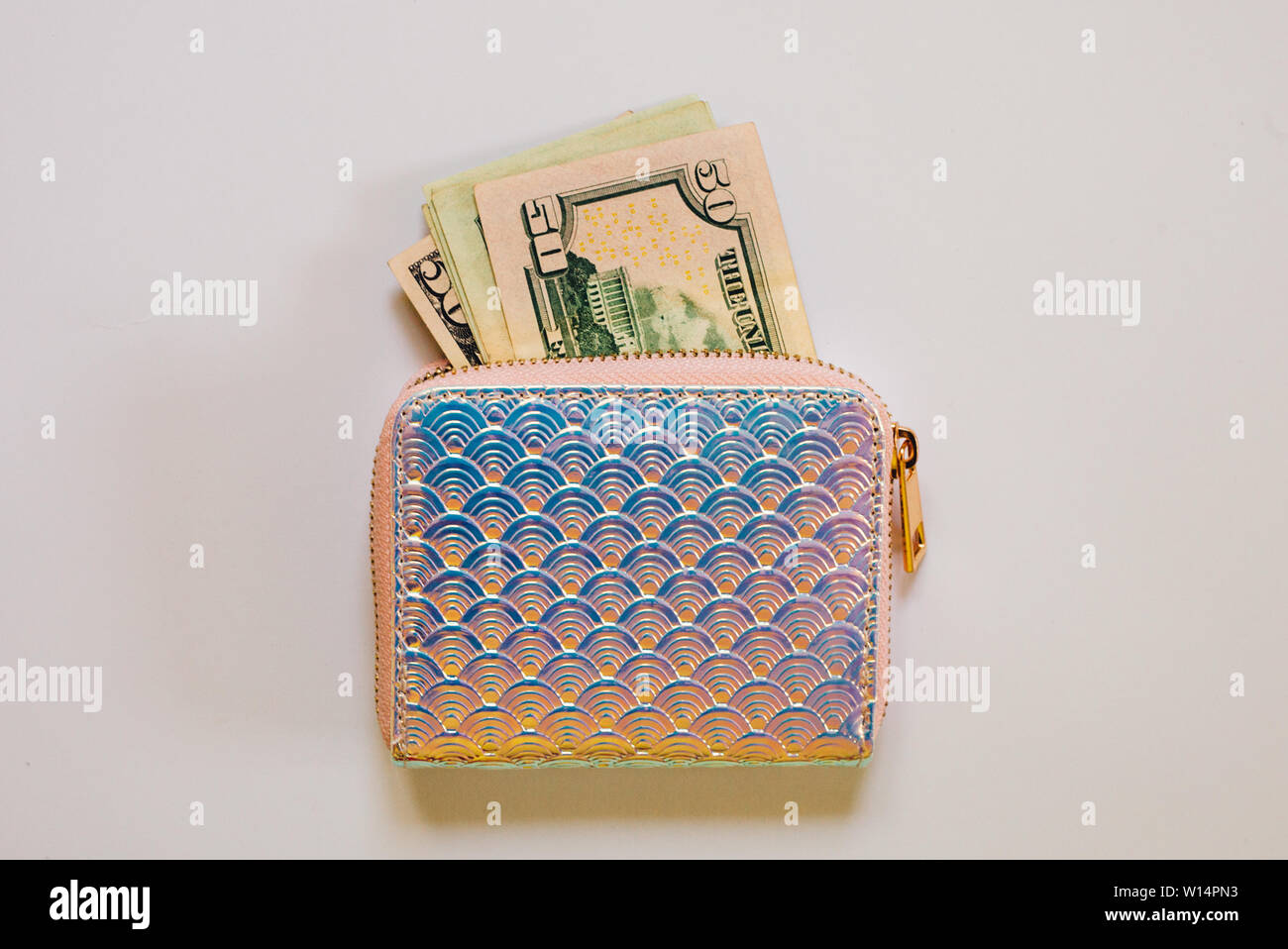 Trendy holographic purse with dollar banknotes on white background ...